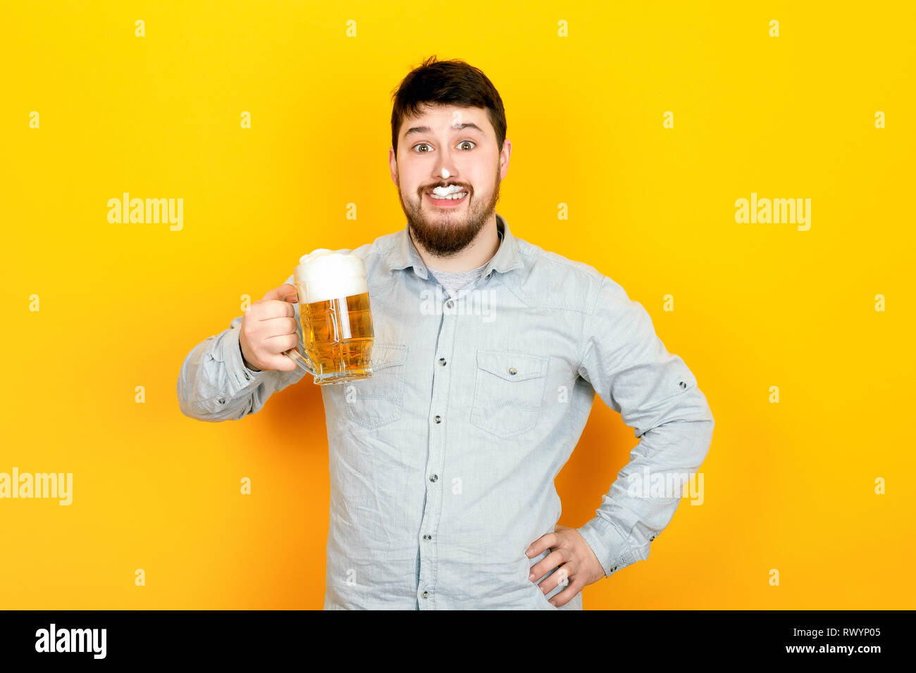 funny man with a glass of beer and foam on his mustache and nose on a ...