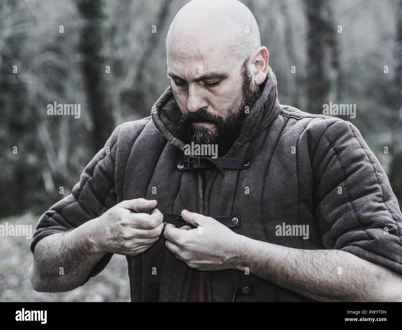Viking tying his gambeson leather armor Stock Photo - Alamy