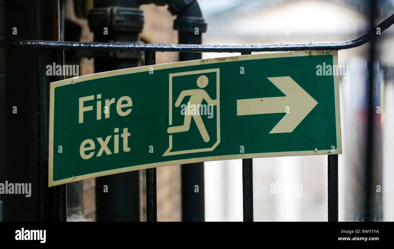 A Fire Exit signage on a steel gate. The gate is black in color and the ...