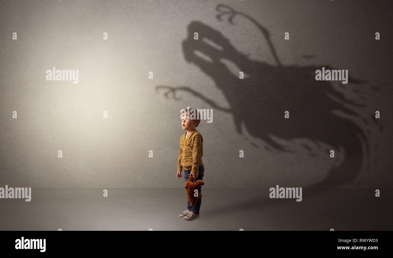 Scary ghost shadow in a dark empty room with a cute blond child Stock ...