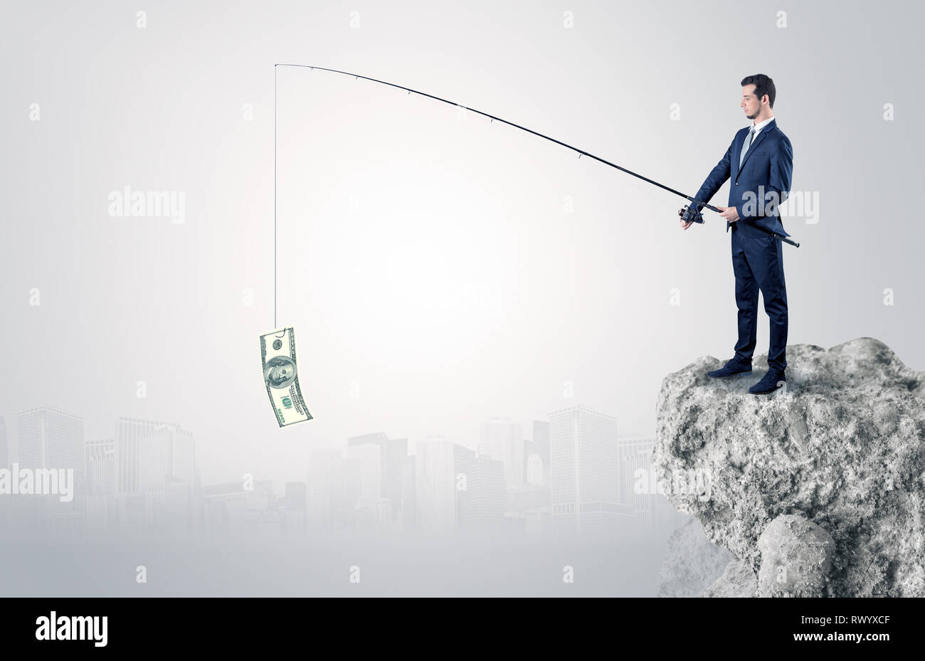 Elegant young businessman fishing cash from a huge rock Stock Photo - Alamy