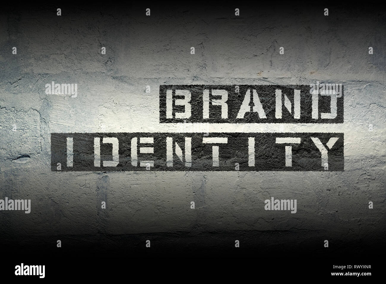 brand identity phrase stencil print on the grunge white brick wall ...