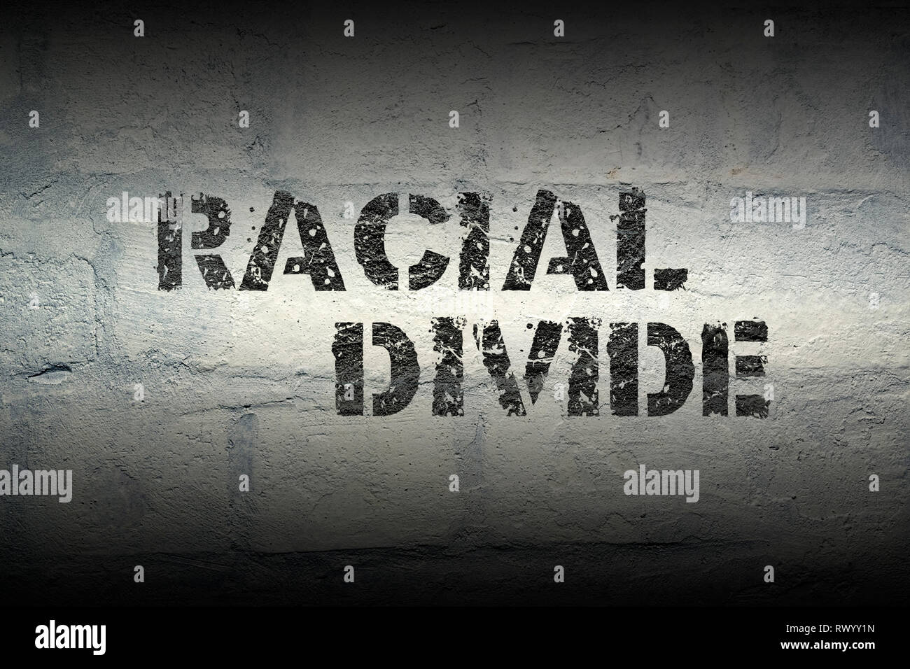 racial divide stencil print on the grunge white brick wall Stock Photo ...