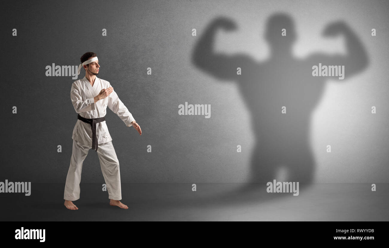 Young karate man fighting with a big black scary shadow Stock Photo - Alamy