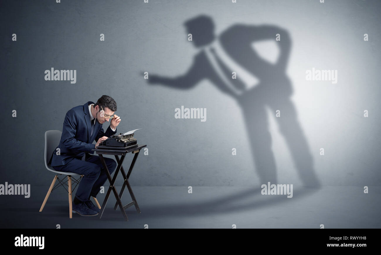 Little man working and a big shadow arguing with him Stock Photo - Alamy