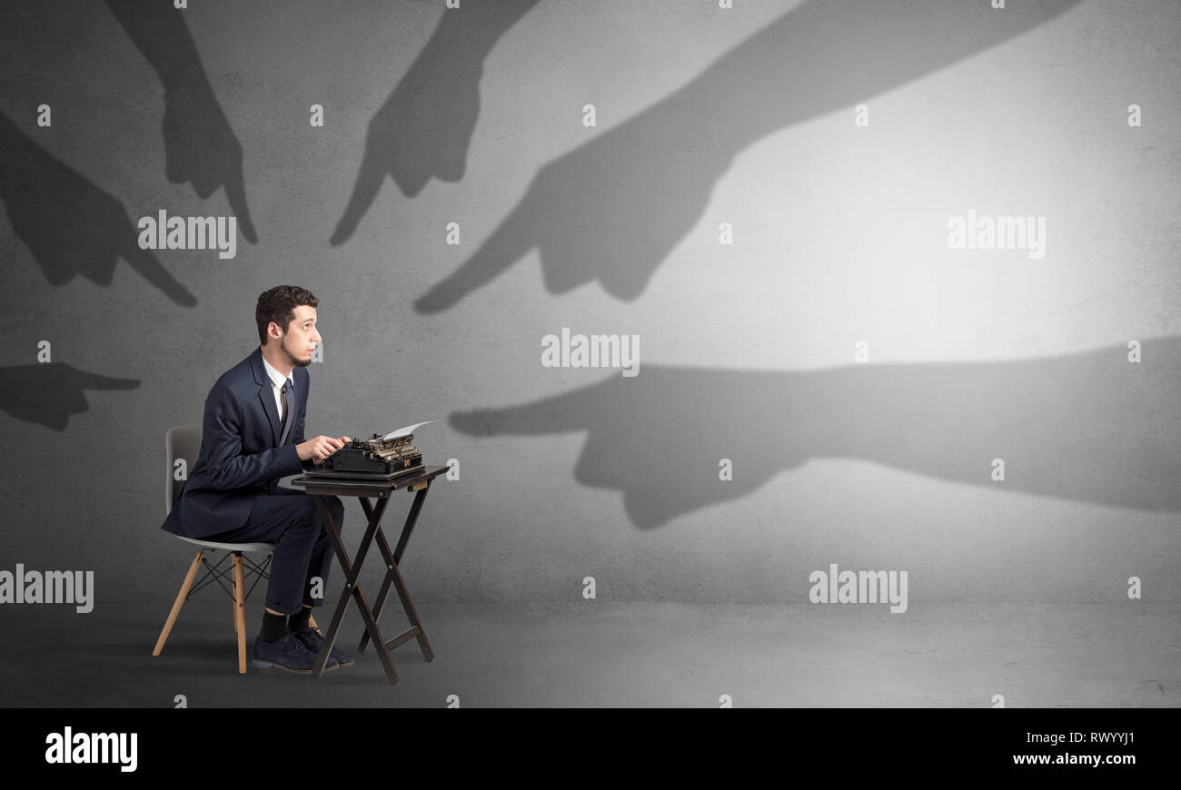 Shadow hand pointing at a small afraid worker Stock Photo - Alamy