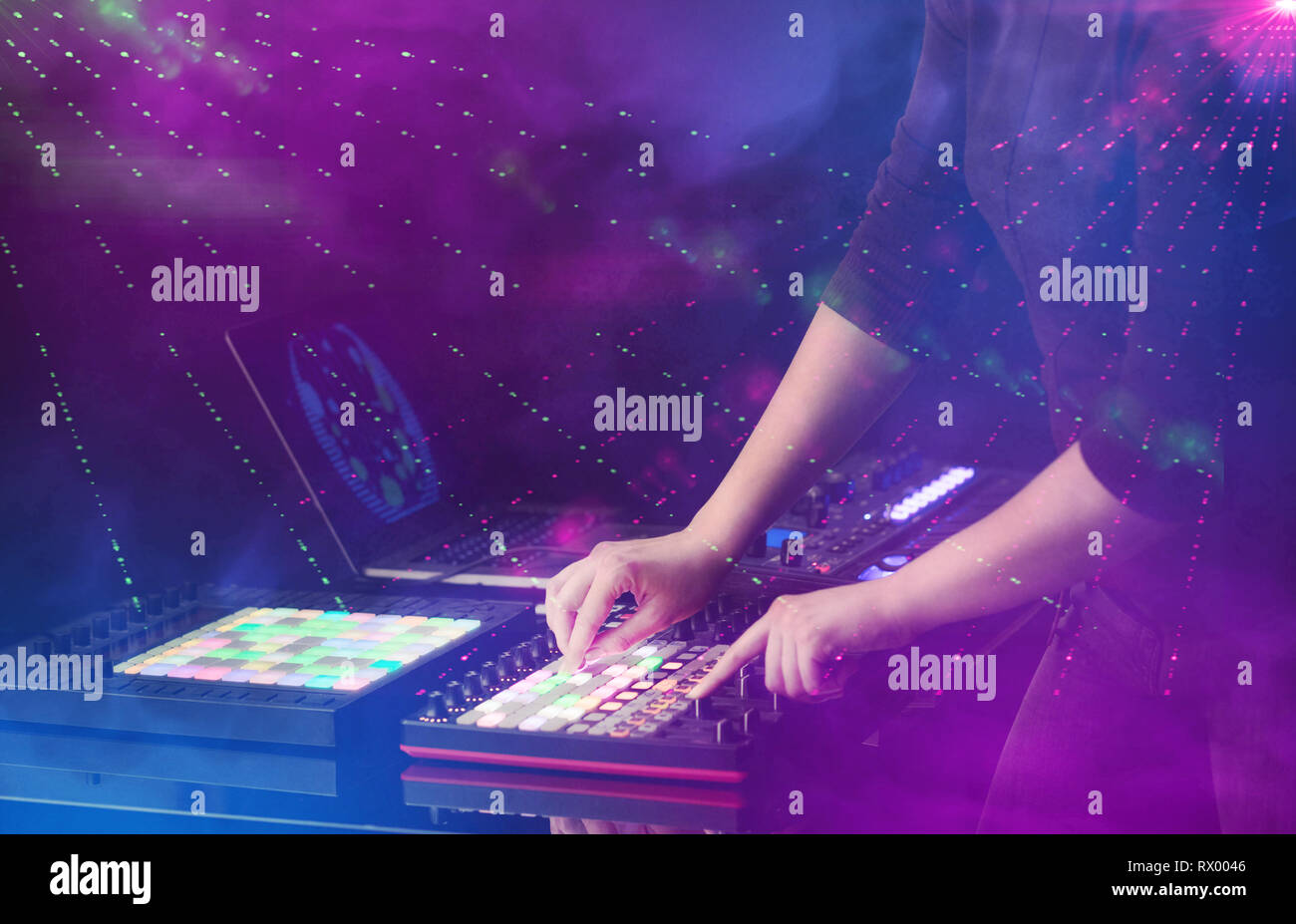 Hand mixing music on midi controller with party club colors around ...