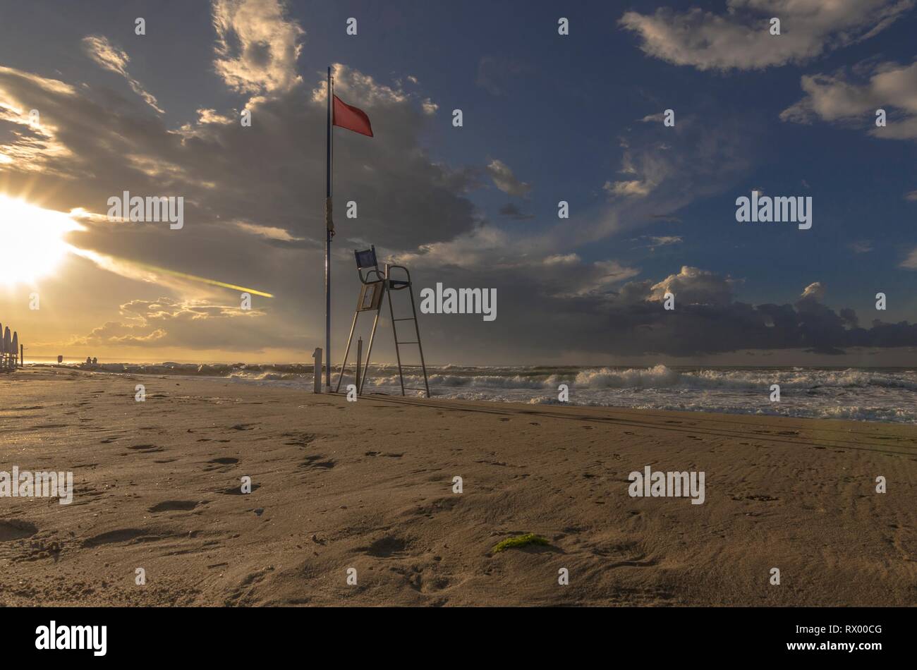 Red warning flag and lifeguard post on the beach Stock Photo - Alamy