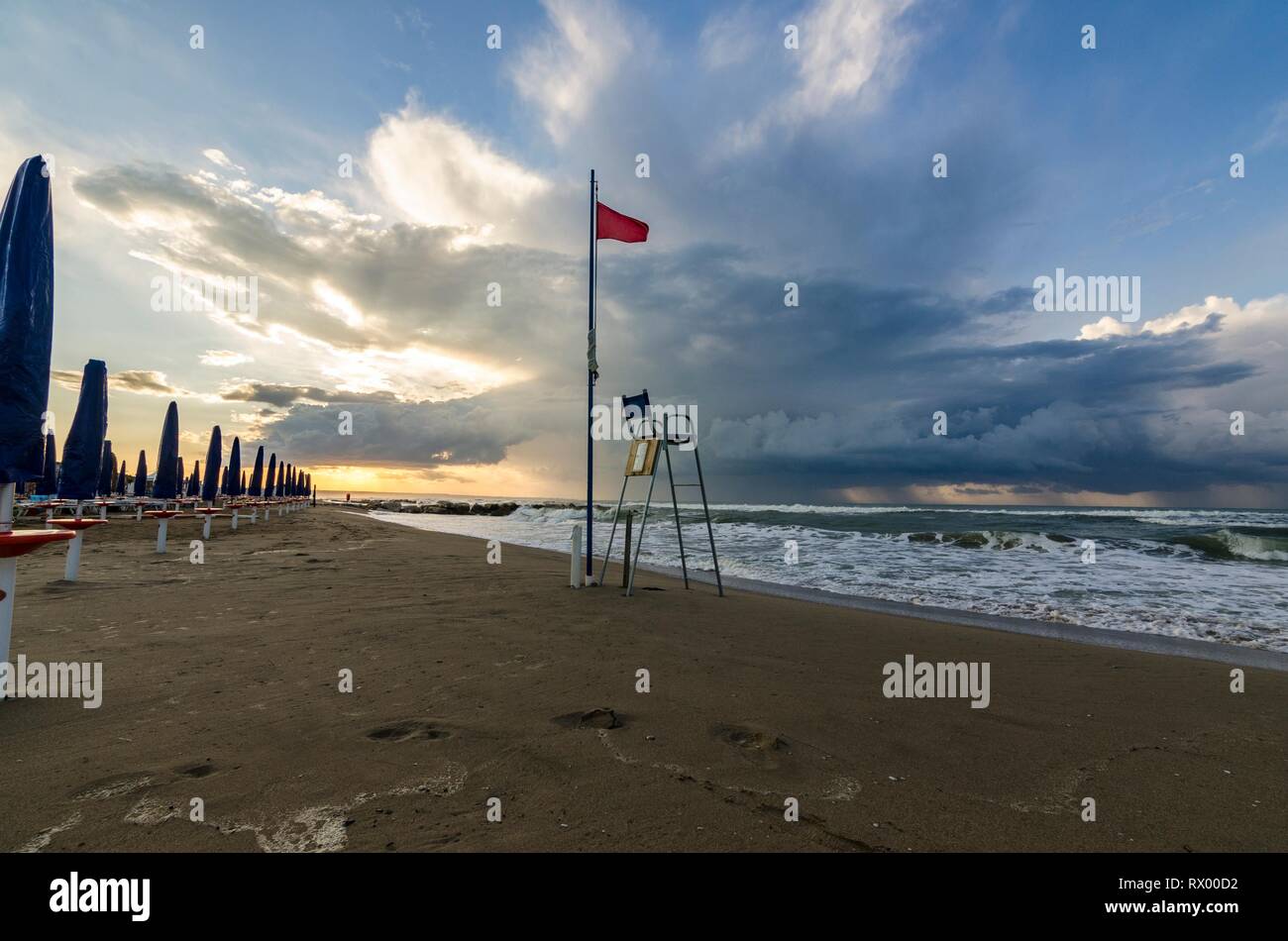 Red warning flag and lifeguard post on the beach Stock Photo - Alamy