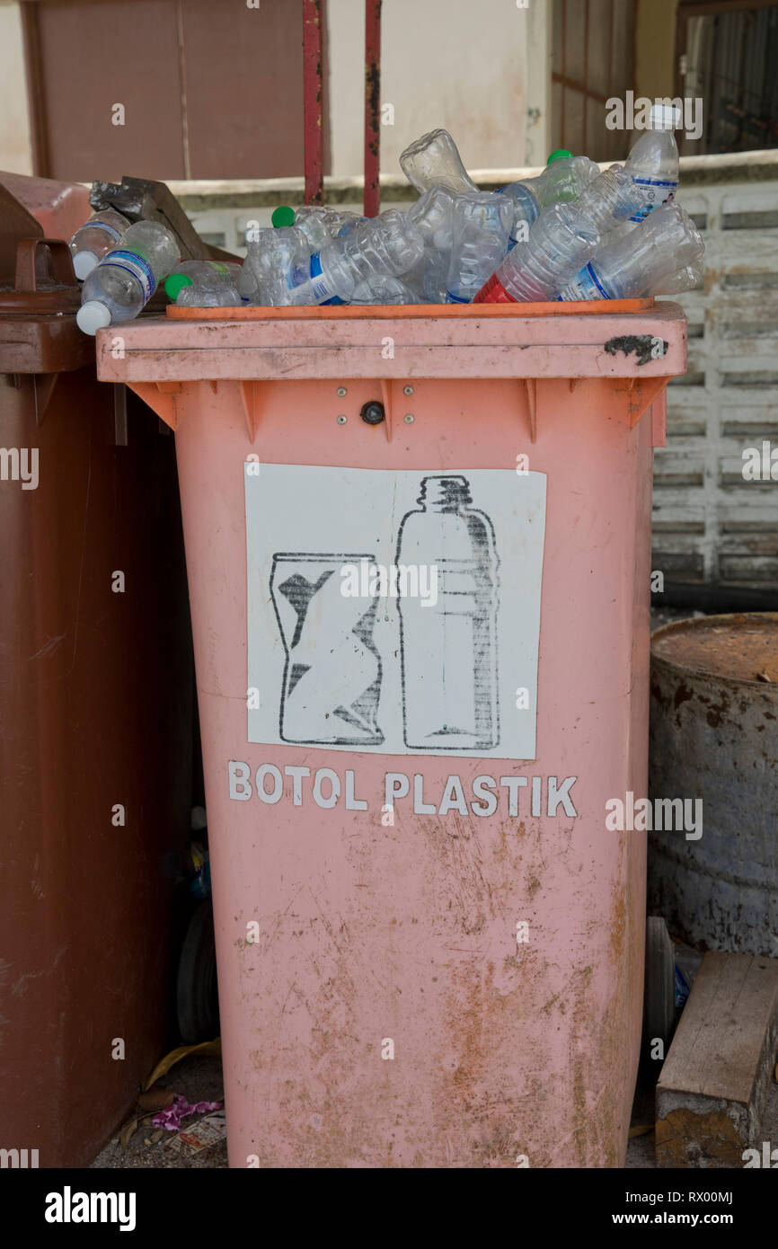Rubbish plastic recycling containers on a beach by the rainforest in ...