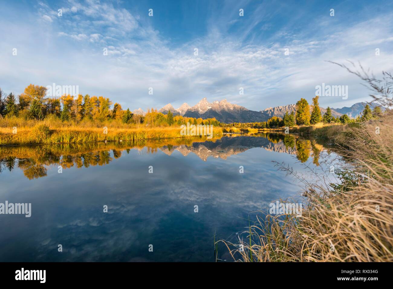 Autumn landscape with Grand Teton Range mountain range, reflected in ...