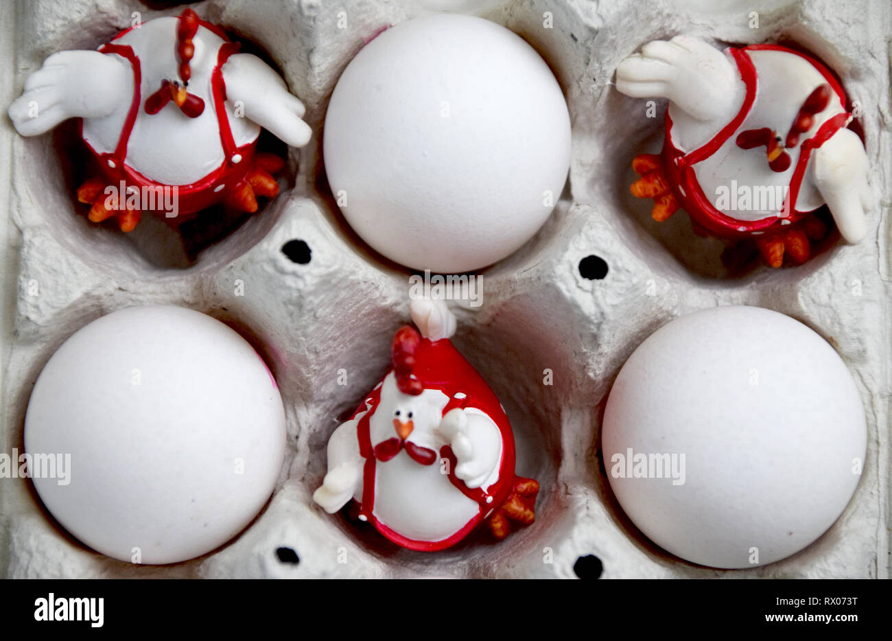 View from above of three Easter rooster decorations and three white ...