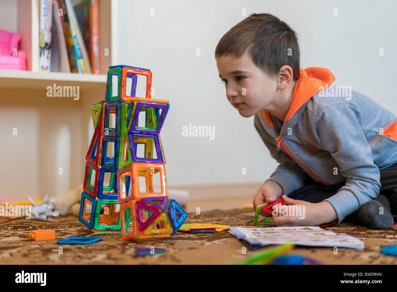 little smiling boy playing with magnetic constructor toy. Boy playing ...
