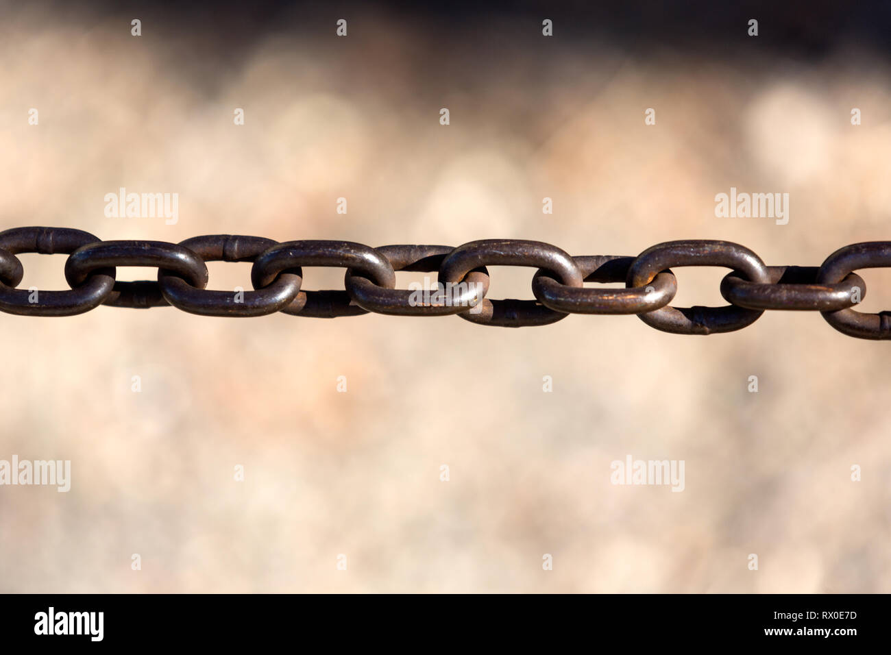 Thick iron chain stretching across a well lit space Stock Photo - Alamy