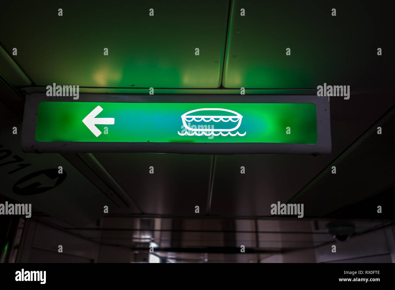 Sign at the roof showing the way to lifeboat stations on board a ship ...