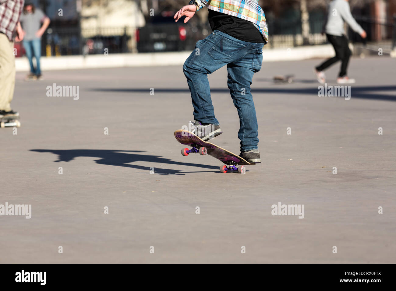 Person riding a skate board in an urban asphalt park Stock Photo - Alamy