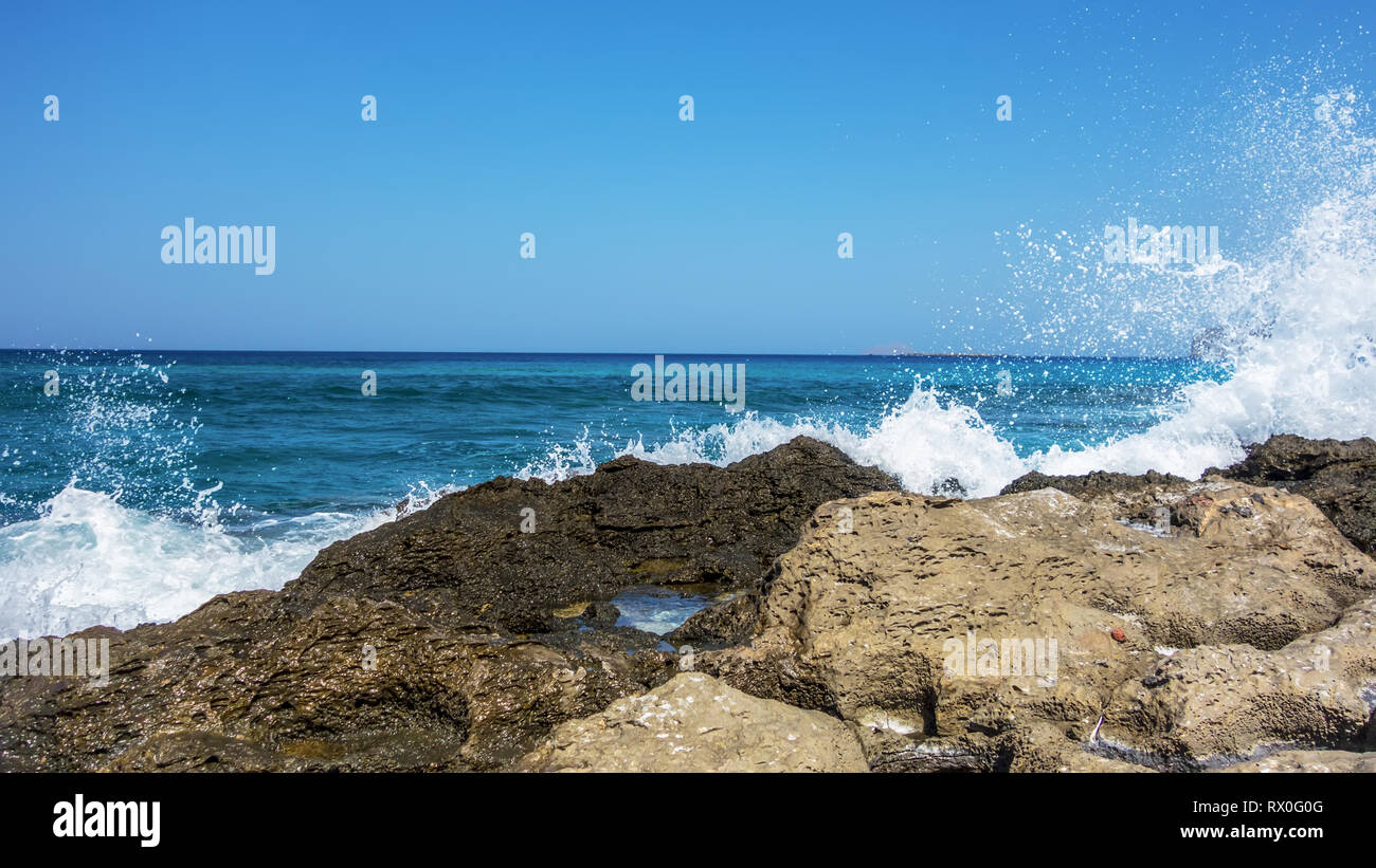 High sea waves with foam and spray breaking on rocks Stock Photo - Alamy