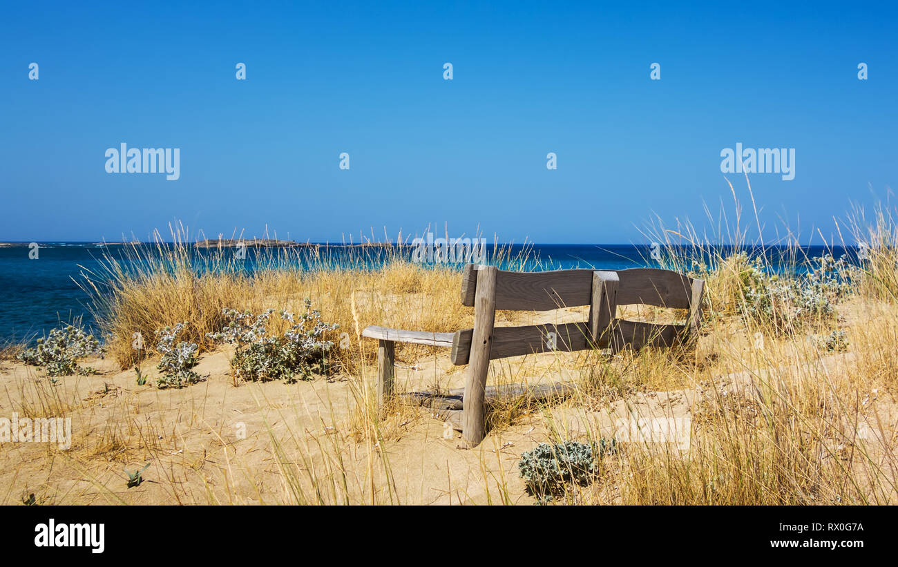 Bench on sea shore, covered with sand, among the sea dunes Stock Photo ...