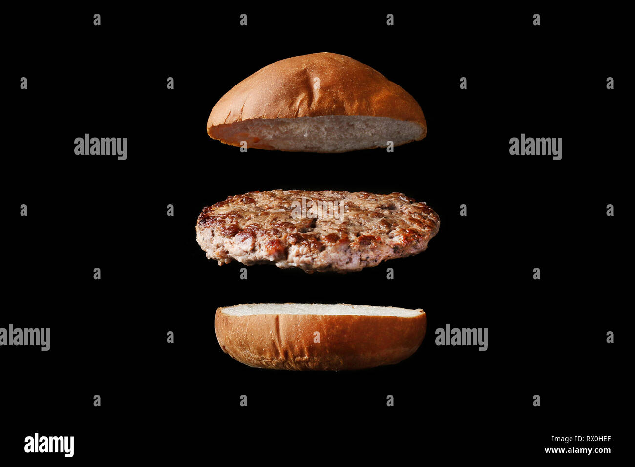 fly burger isolated on black back. bun and meat Stock Photo - Alamy
