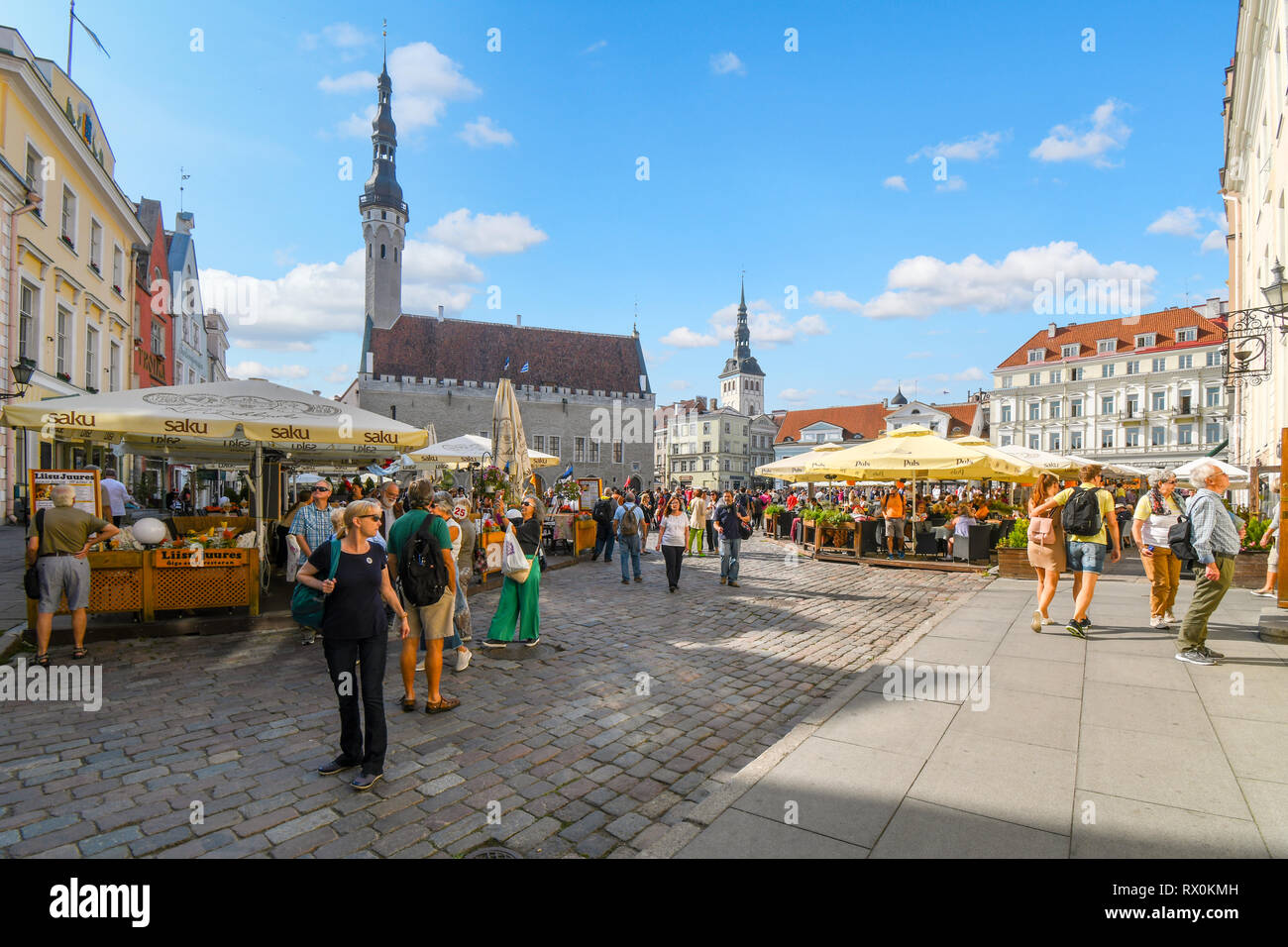 Tourists crowd the sidewalk cafes and shops in the medieval Tallinn ...