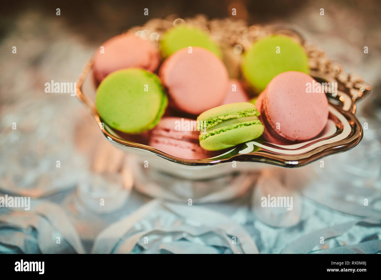 Colorful macarons stand in round transparent weight as part of candy ...