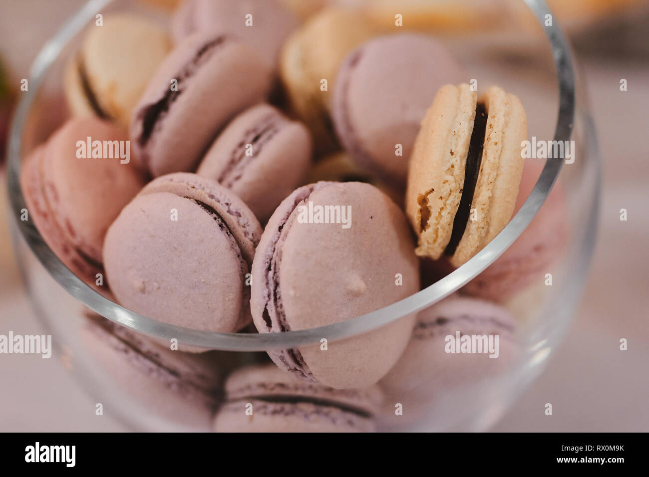 Colorful macarons stand in round transparent weight as part of candy ...