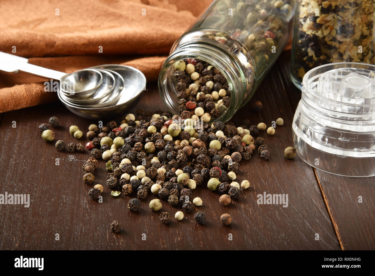 White and black peppercorns spilling out of a spice bottle Stock Photo ...