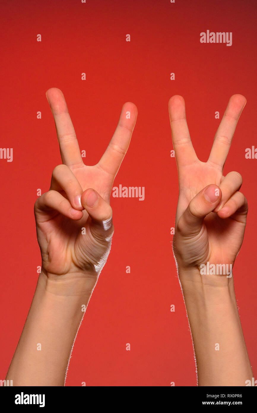 Two beautiful hands showing a victory sign isolated on a green ...