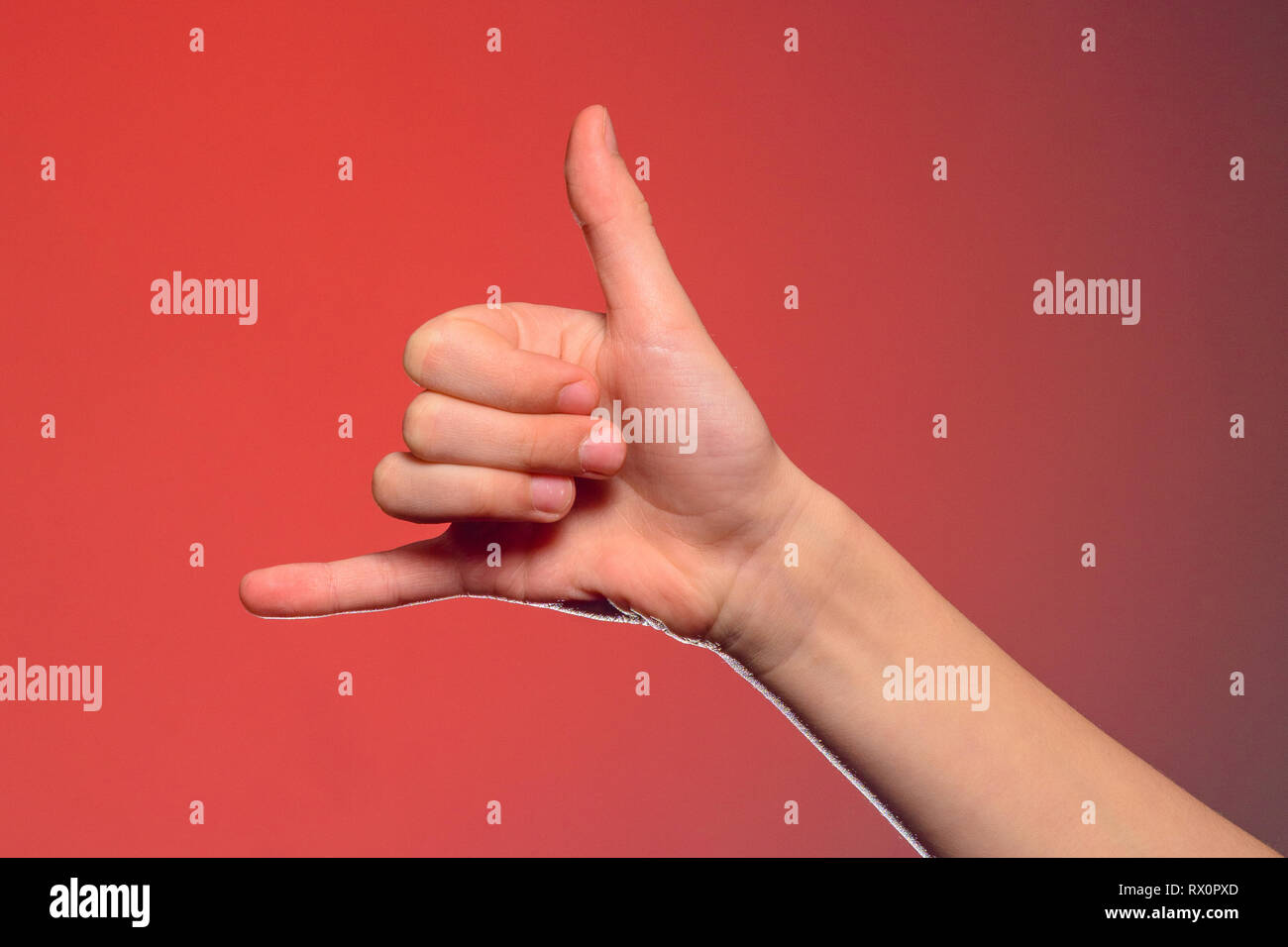 The sign of a phone call shows one-handed isolated on a red background ...