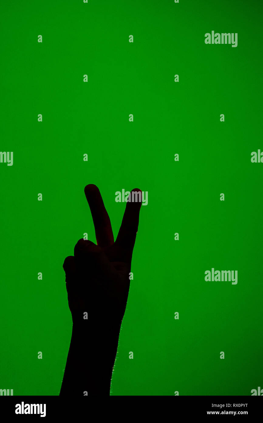 The soft hand showing the victory sign is isolated on a red background ...