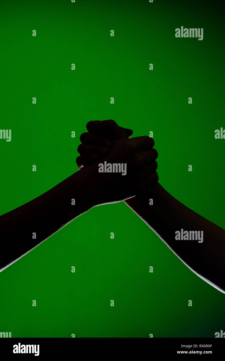 Two hands handshake, isolated on a green background, symbolizing ...