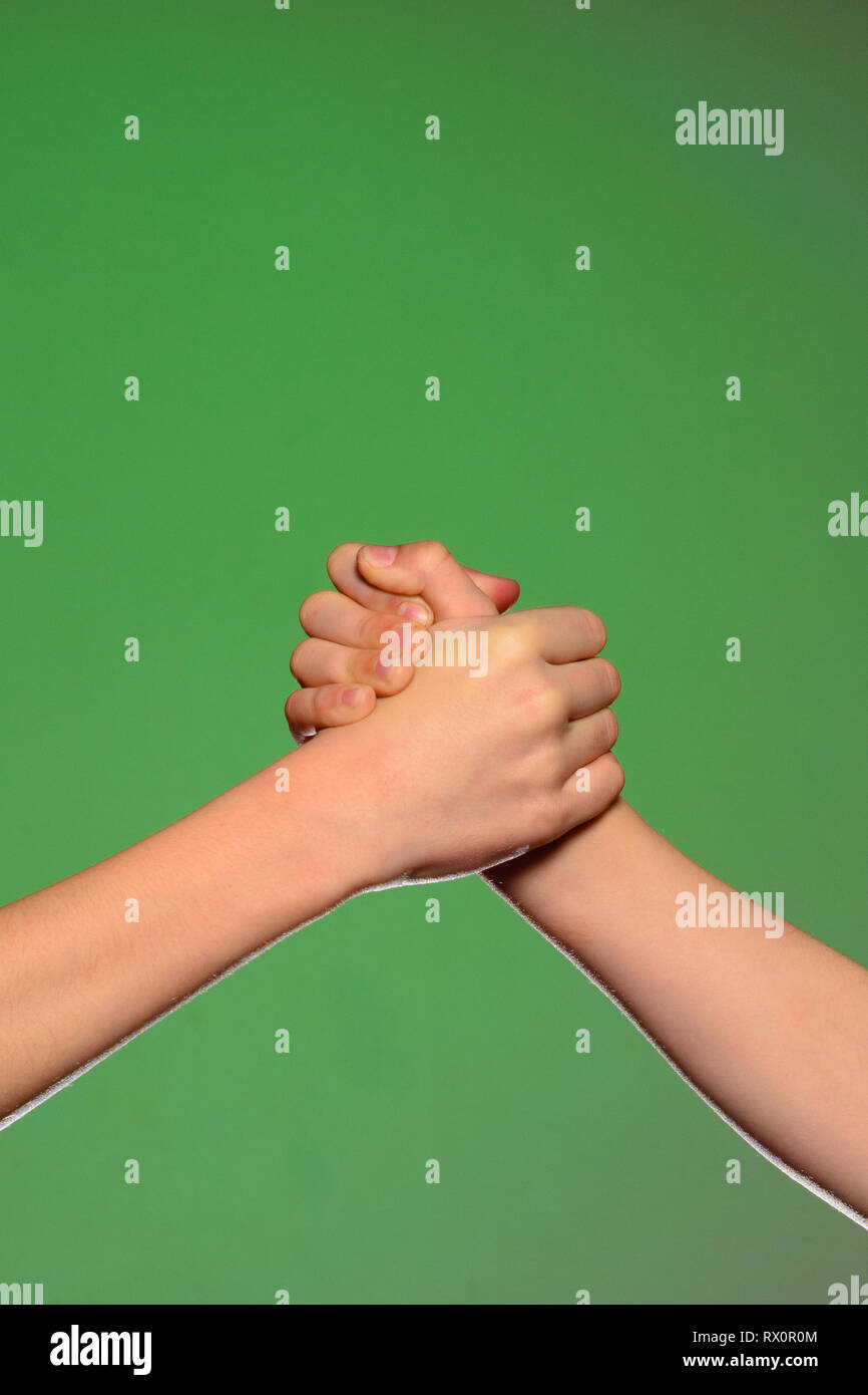 Two hands handshake, isolated on a green background, symbolizing ...
