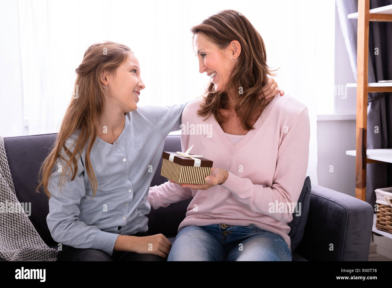 Portrait Of A Girl Giving Gift To Her Happy Mother Stock Photo - Alamy