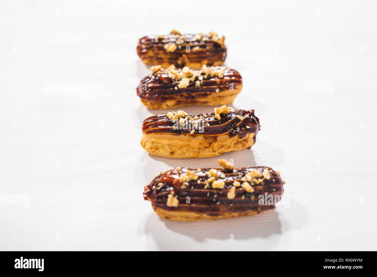 Food, bakery and desserts concept - row of eclairs on white background ...