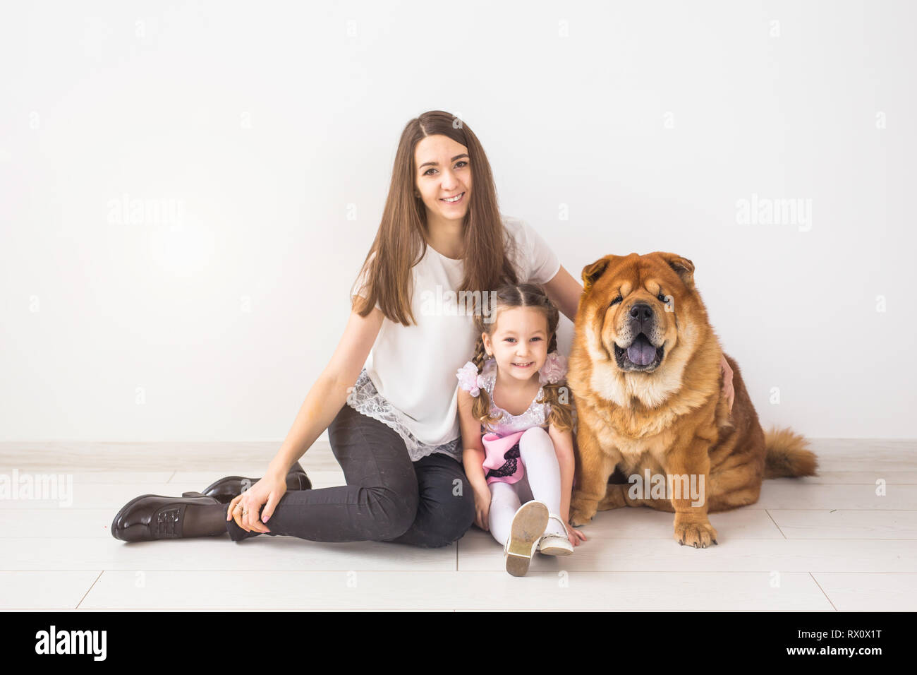 Pet, children and family concept - Little girl and her mother hugging ...