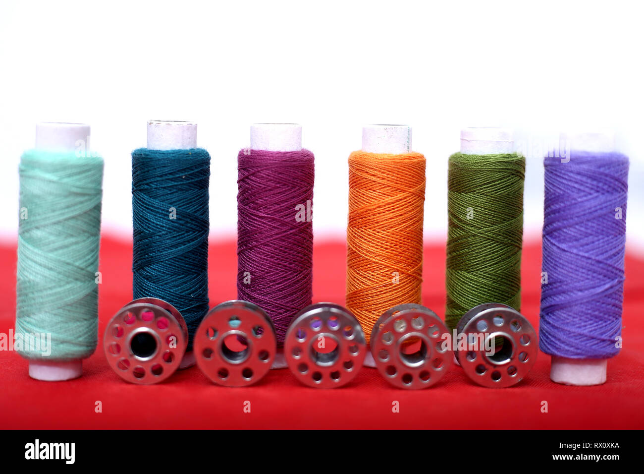 Portrait of spool thread and bobbin on the red cloth Stock Photo - Alamy