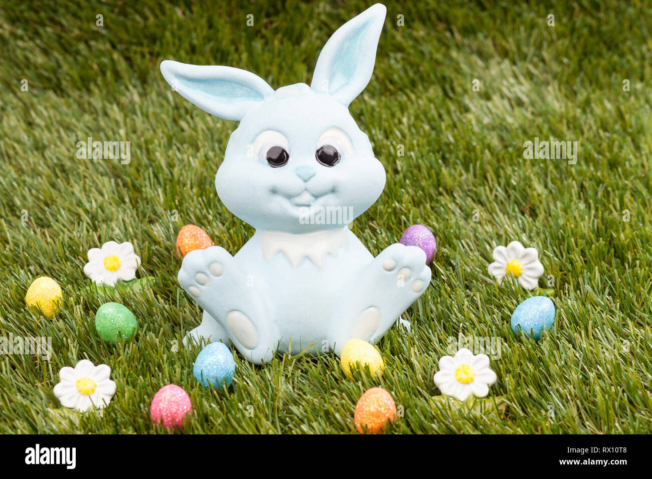 Easter bunny sitting on grass surrounded by colourful easter eggs Stock ...