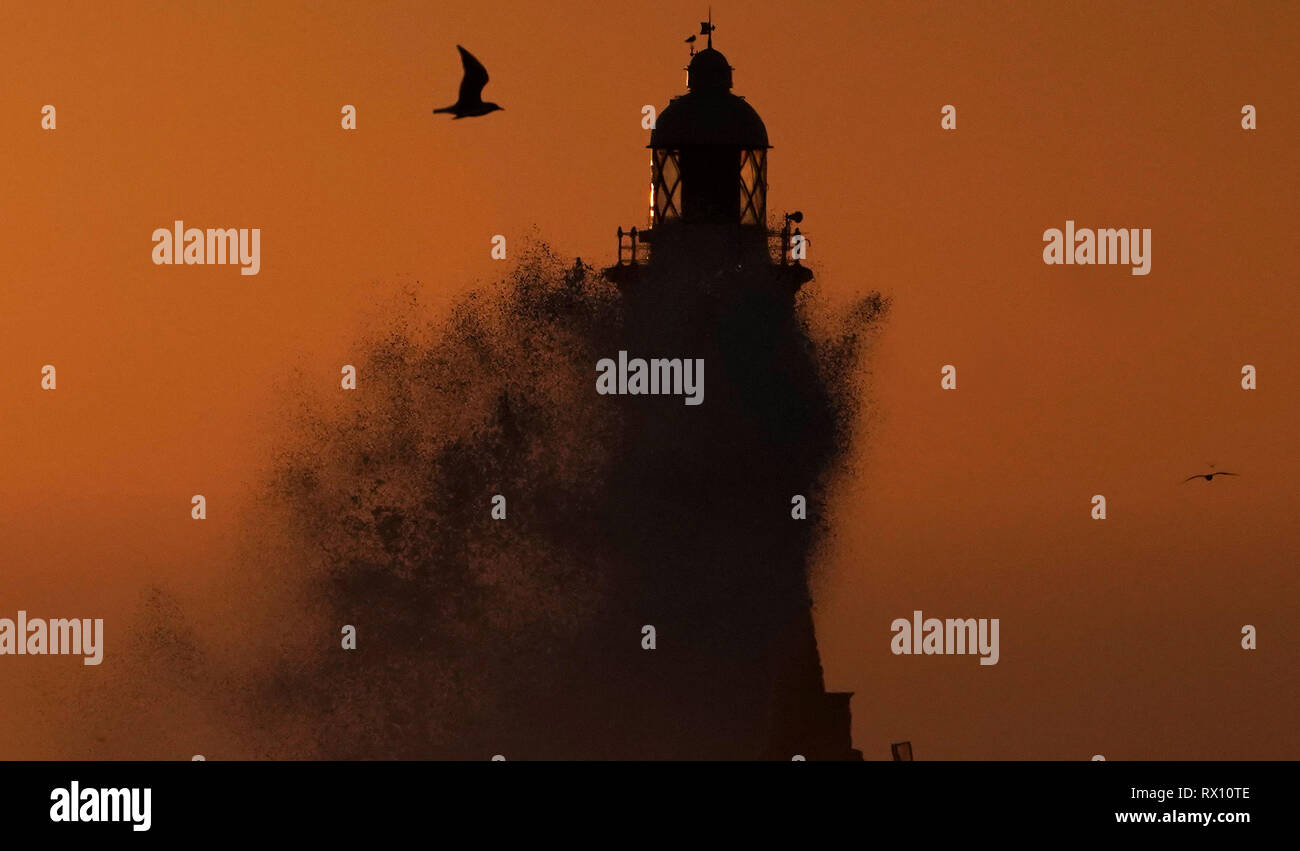 Waves from the North Sea crash against the Tynemouth Lighthouse wall at ...