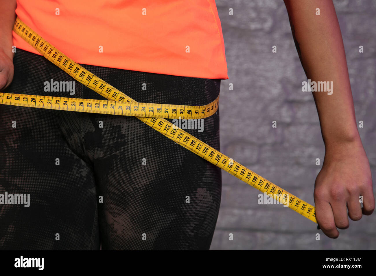 girl uses a measuring cup to measure the body's circumference Stock ...