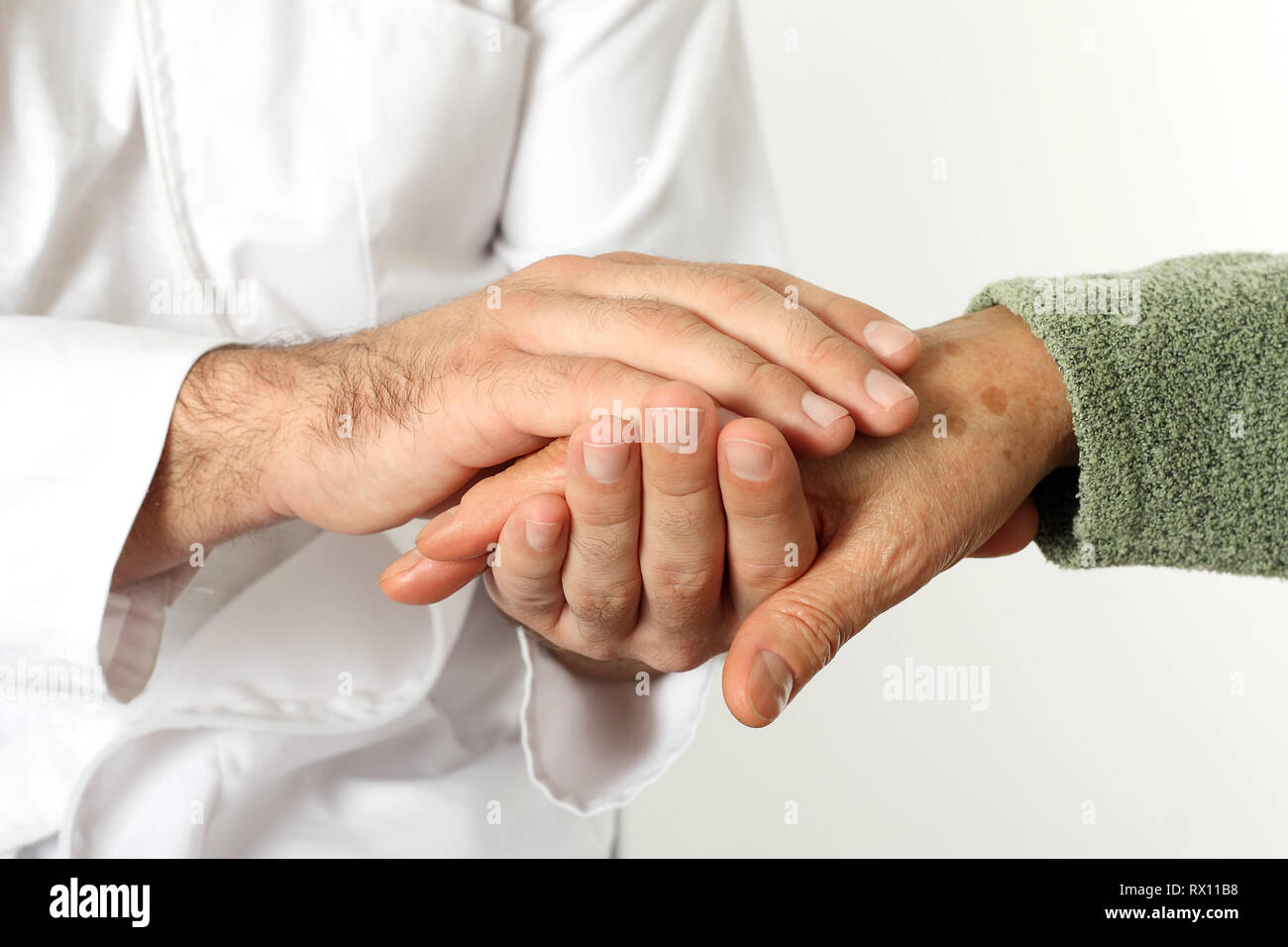 Male doctor holding patient hand Stock Photo - Alamy