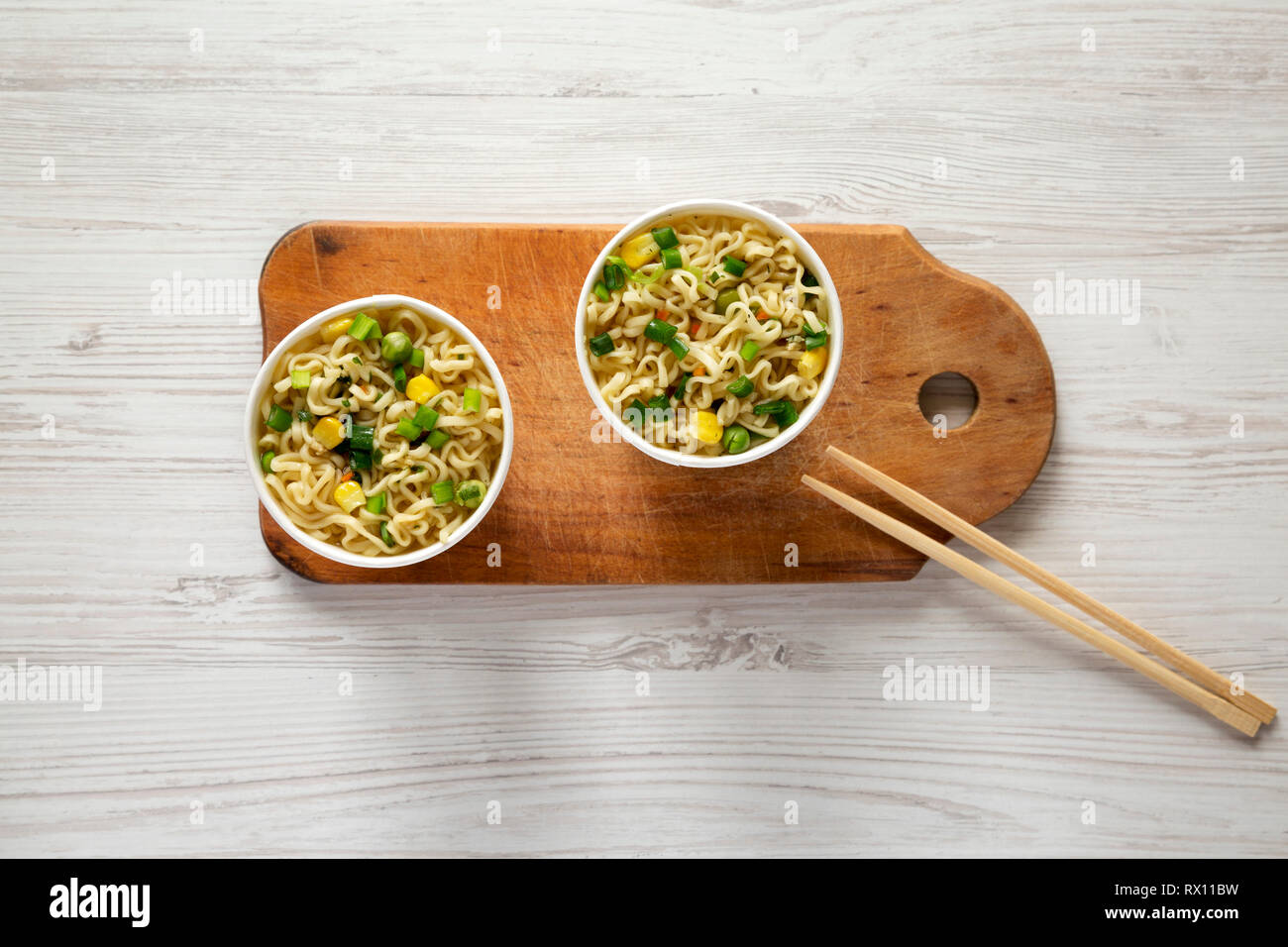 Tasty instant ramen noodles with beef flavoring on rustic wooden board ...