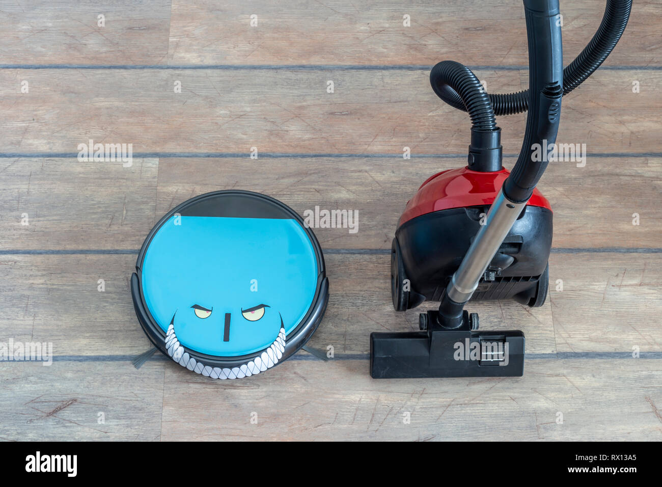 Robot vacuum cleaner with evil eyes and grin and regular vacuum ...