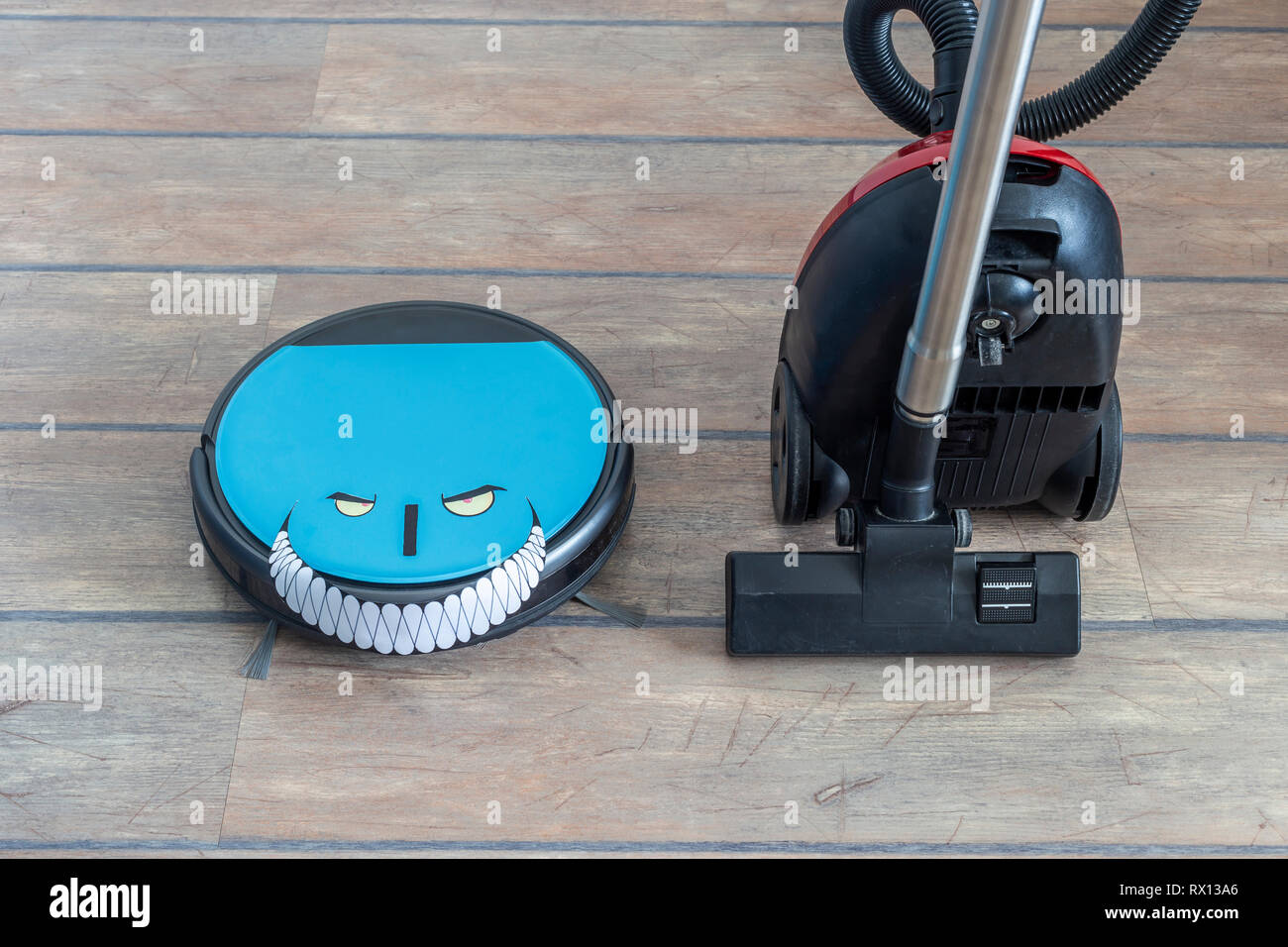 Robot vacuum cleaner with evil eyes and grin and regular vacuum ...