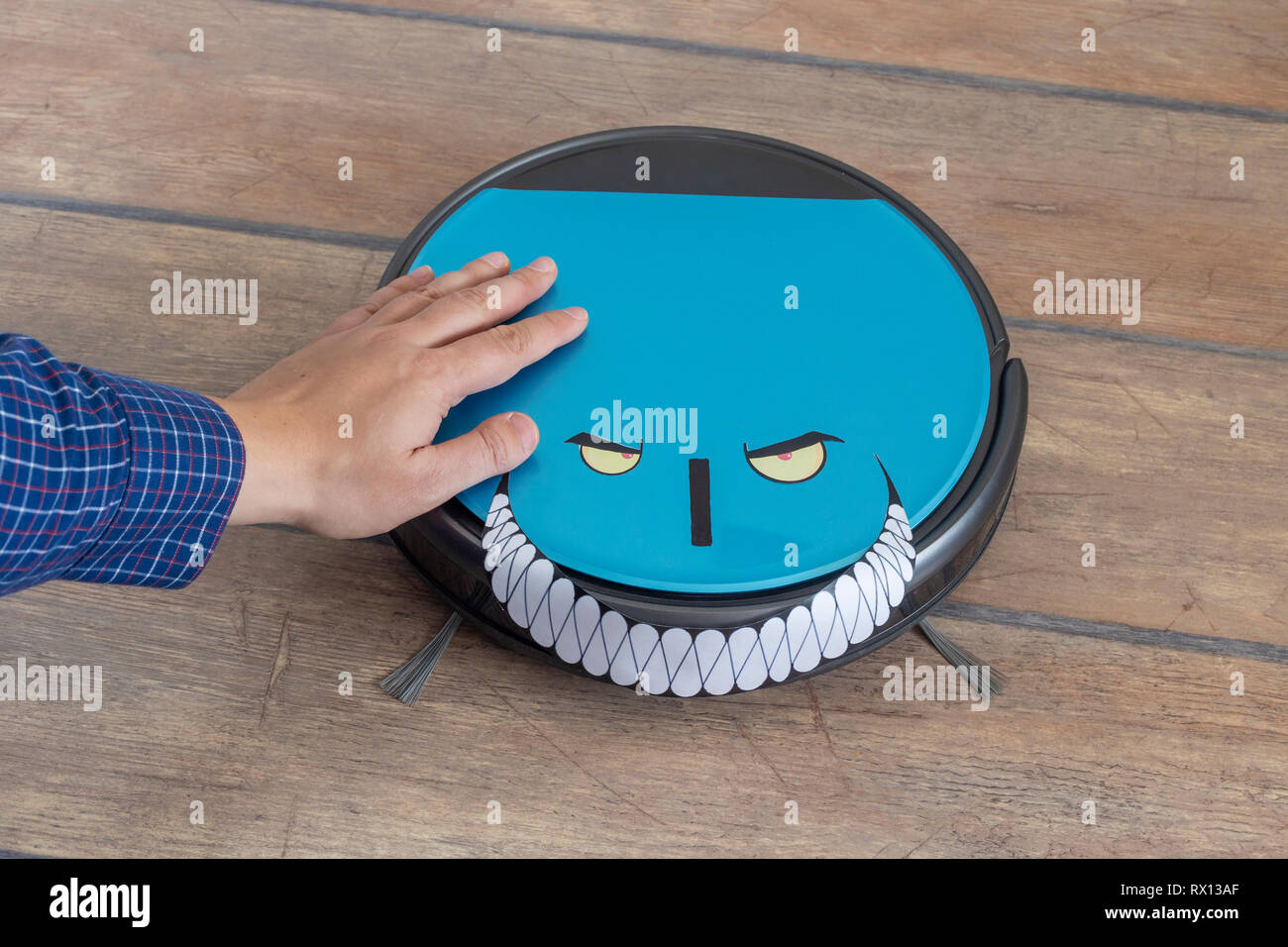 Hand petting a robot vacuum cleaner. Evil robots and takeover concept ...