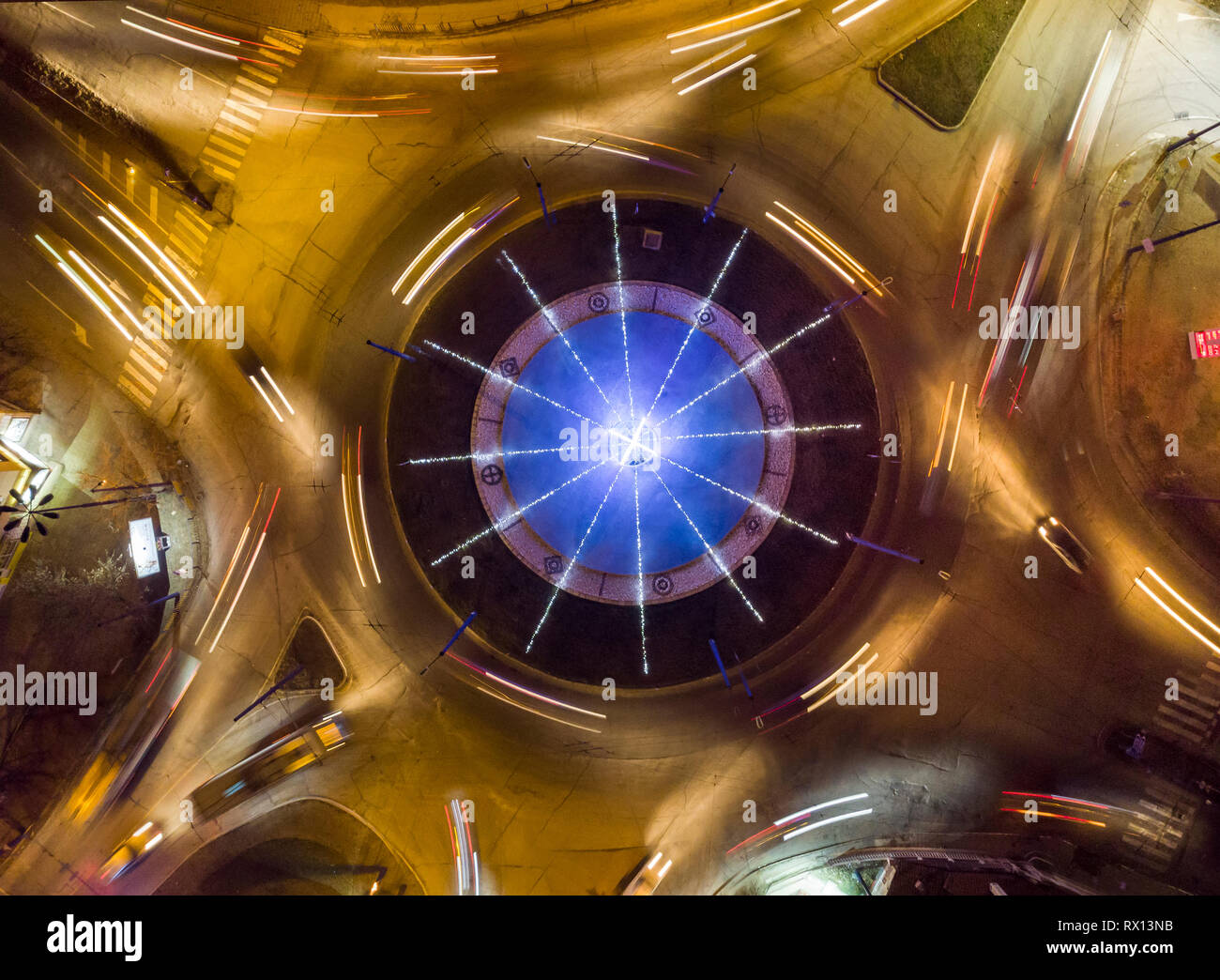 Aerial view of a roundabout at night. Many car trails show busy city ...