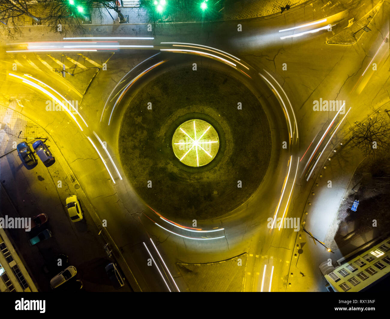Aerial view of a roundabout at night. Many car trails show busy city ...