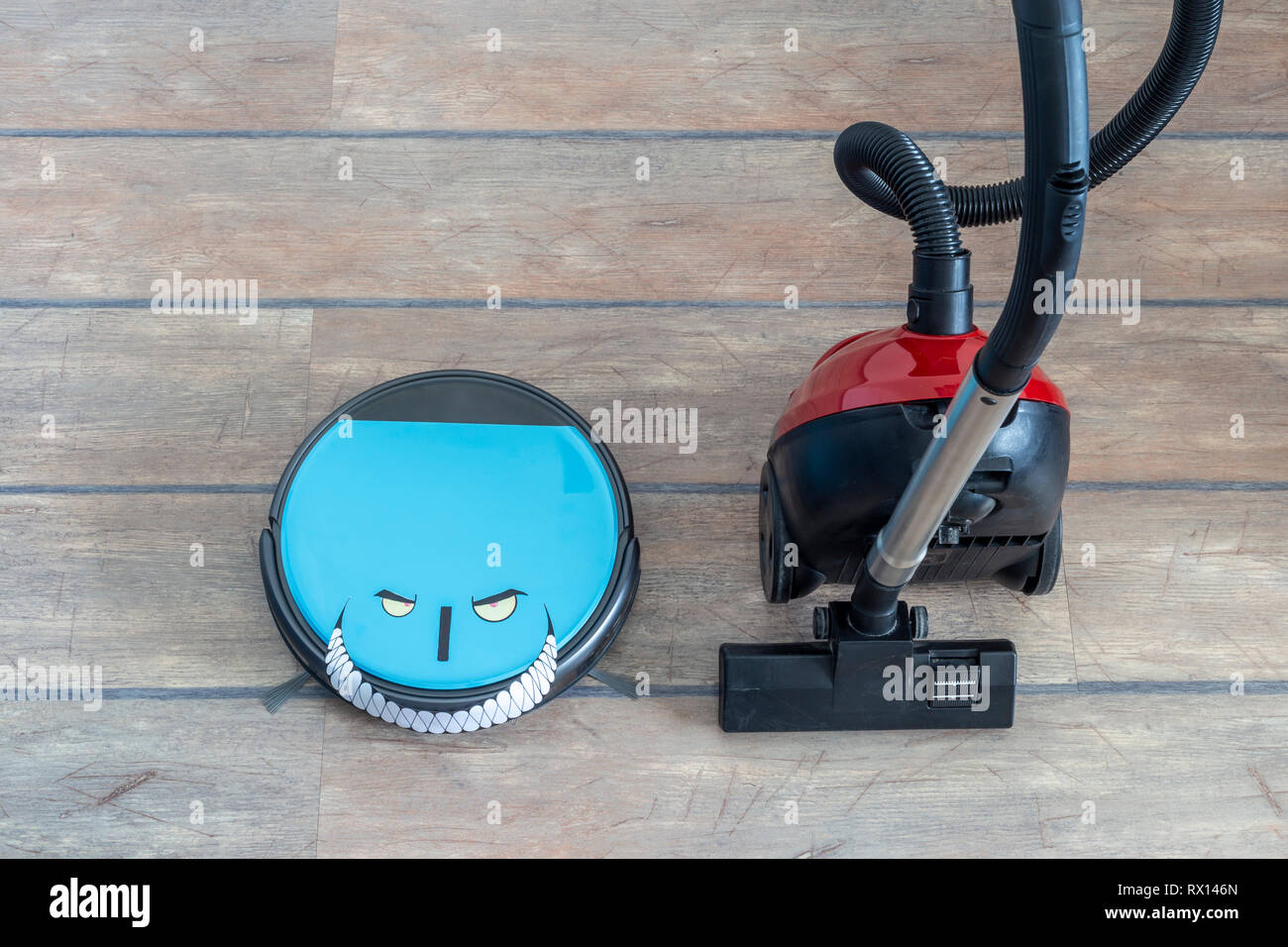 Robot vacuum cleaner with evil eyes and grin and regular vacuum ...