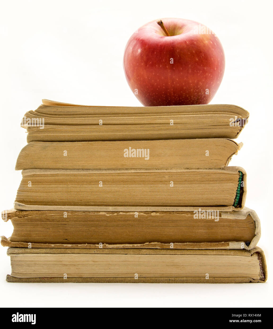 Stack of old books with red apple isolated Stock Photo - Alamy