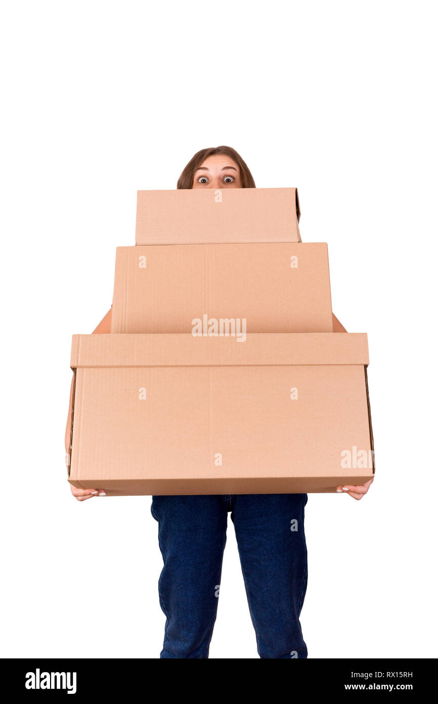 Portrait of a young delivery woman looking behind boxes and holding ...