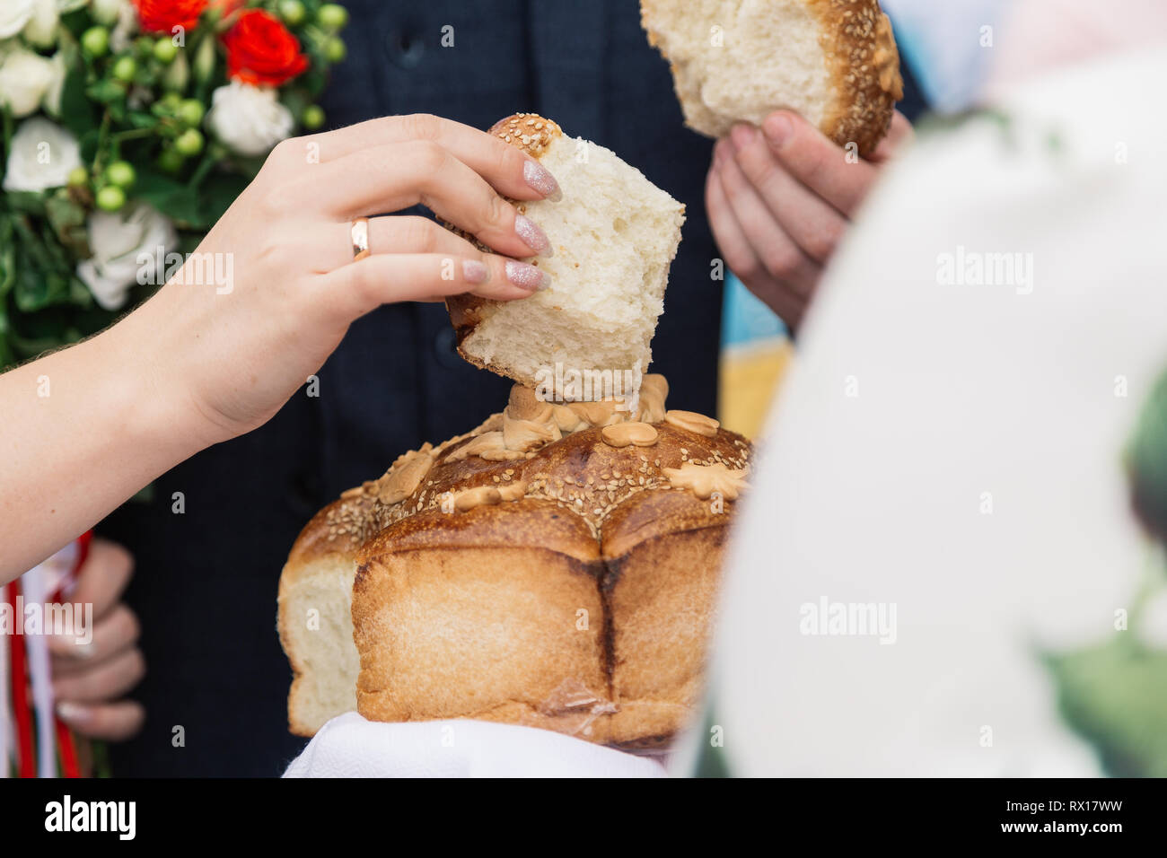 The bride and groom break the wedding loaf Stock Photo - Alamy